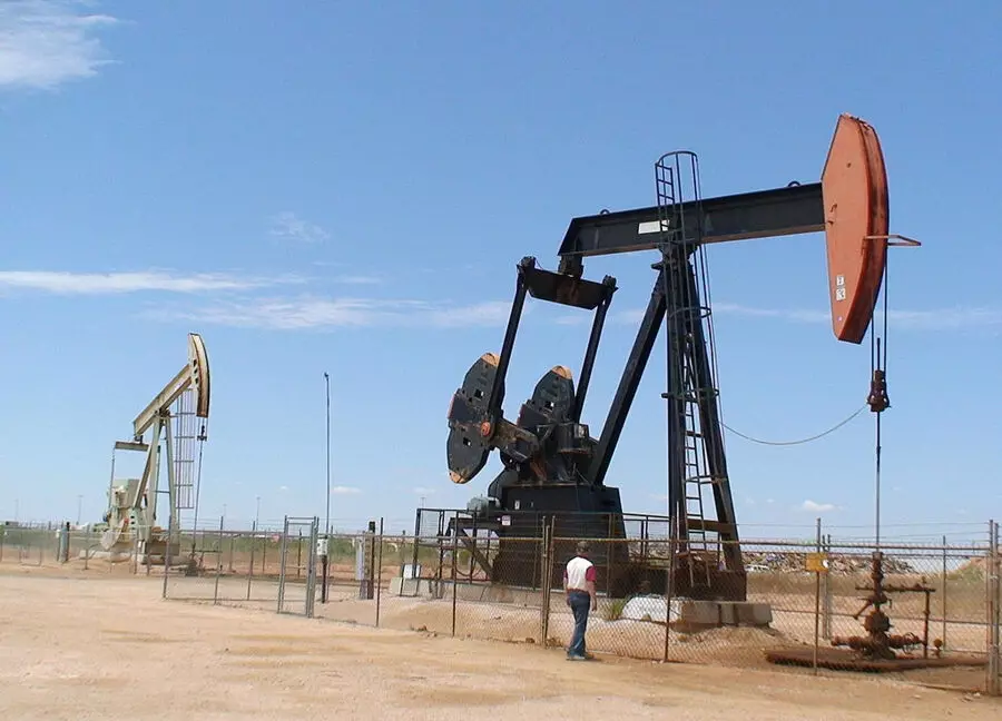 GAAT MET AFP-VERHAAL: Grondstoffen-olie-energie-prijs-VS-boom-misdaad, diefstallen in olievelden nemen toe in Texas te midden van sterk stijgende prijzen door Mira Oberman. Deze foto van 24 juni 2008 toont olieboorplatforms in Midland County, Texas. De wijd open olievelden van West-Texas zijn tegenwoordig rijp voor dieven. Sommigen rijden naar een van de duizenden pompvijzels die overal op het platteland te vinden zijn en zuigen ruwe olie uit de opslagtanks. Sommigen trekken naar een boorlocatie nadat de bemanningen de nacht hebben doorgebracht en slepen gereedschap, leidingen en apparatuur weg. Anderen nemen smeergeld, dienen valse facturen in of stelen gewoon, wetende dat hun bazen het te druk hebben met de oliehausse om de boekhouding nauwlettend in de gaten te houden. AFP PHOTO/COR (Fotocredit zou MIRA OBERMAN/AFP/Getty Images moeten zijn)